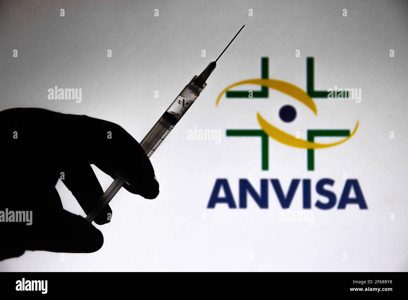 In this photo illustration, a medical syringe held with the National ...