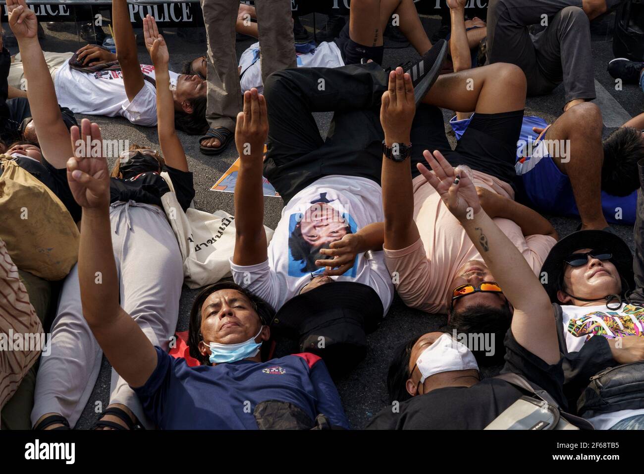 Protestors laying down seen making the three-finger salute in front of ...