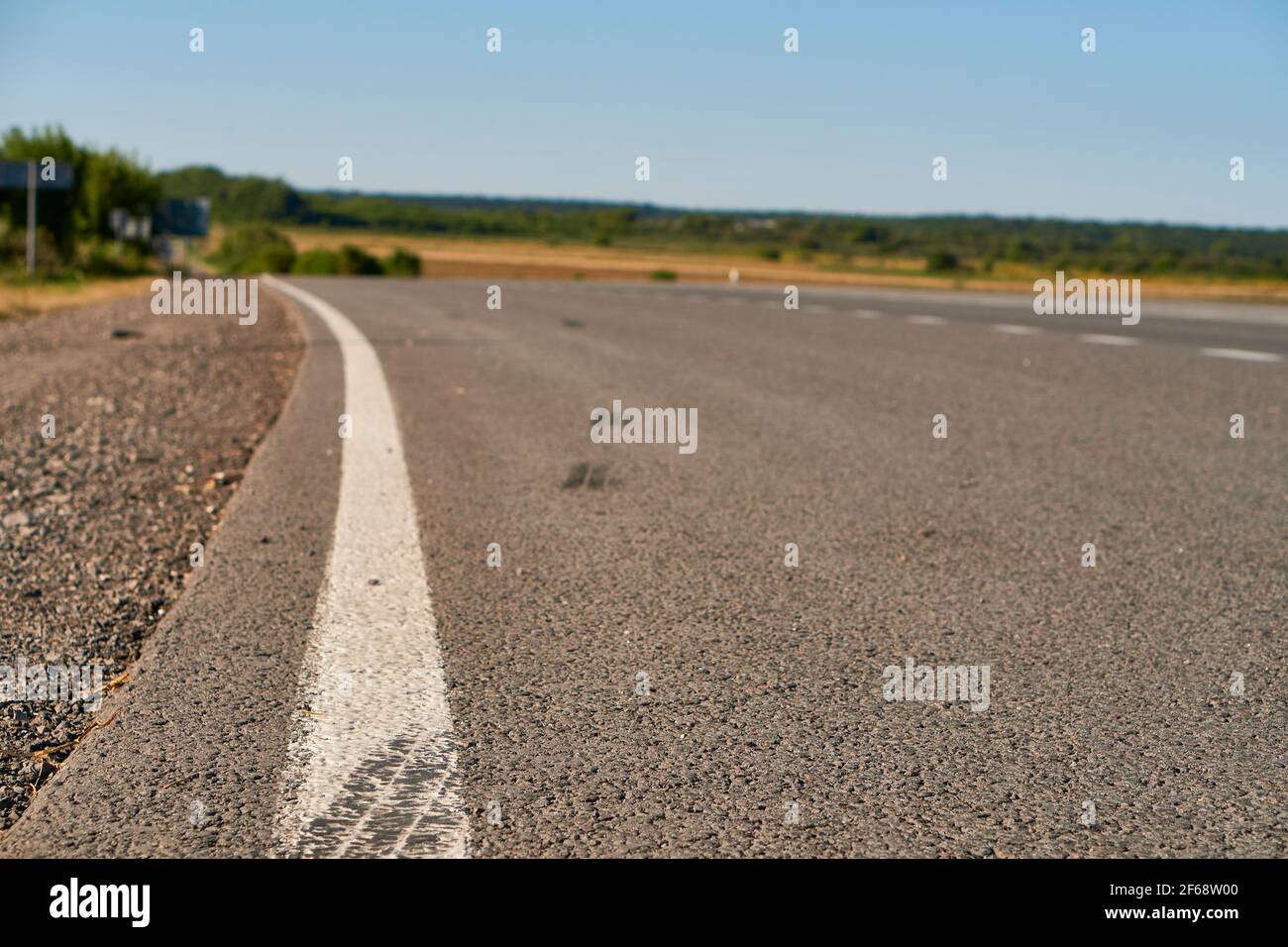 soft focus asphalt road surface with white markings close-up from the ...