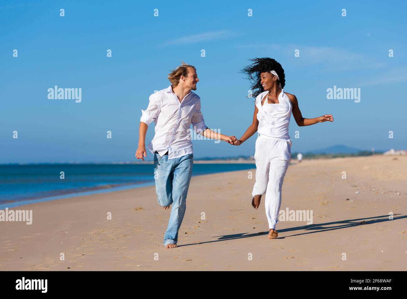Couple - black woman and Caucasian man - walking and running down a ...