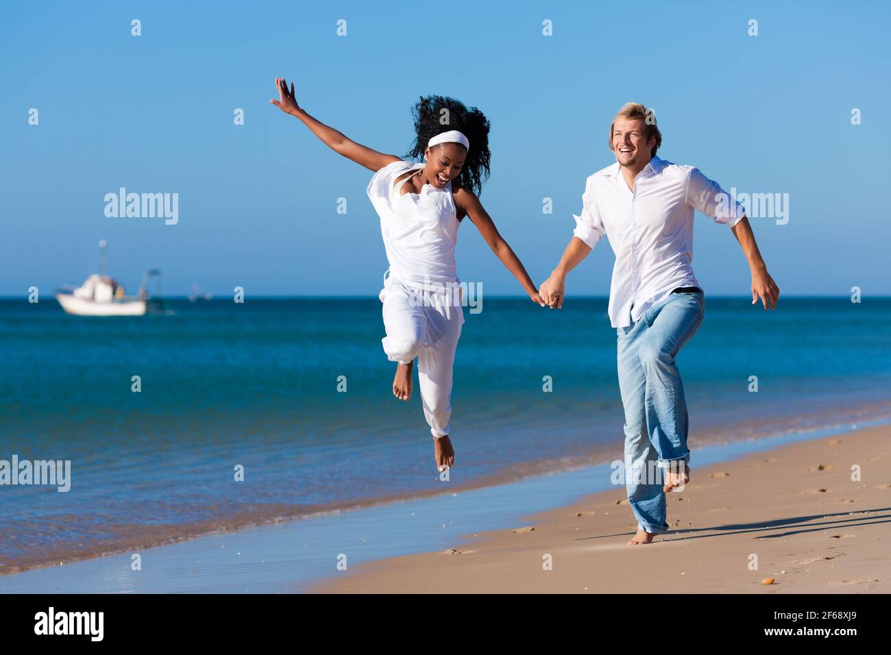 Couple - black woman and Caucasian man - walking and running down a ...