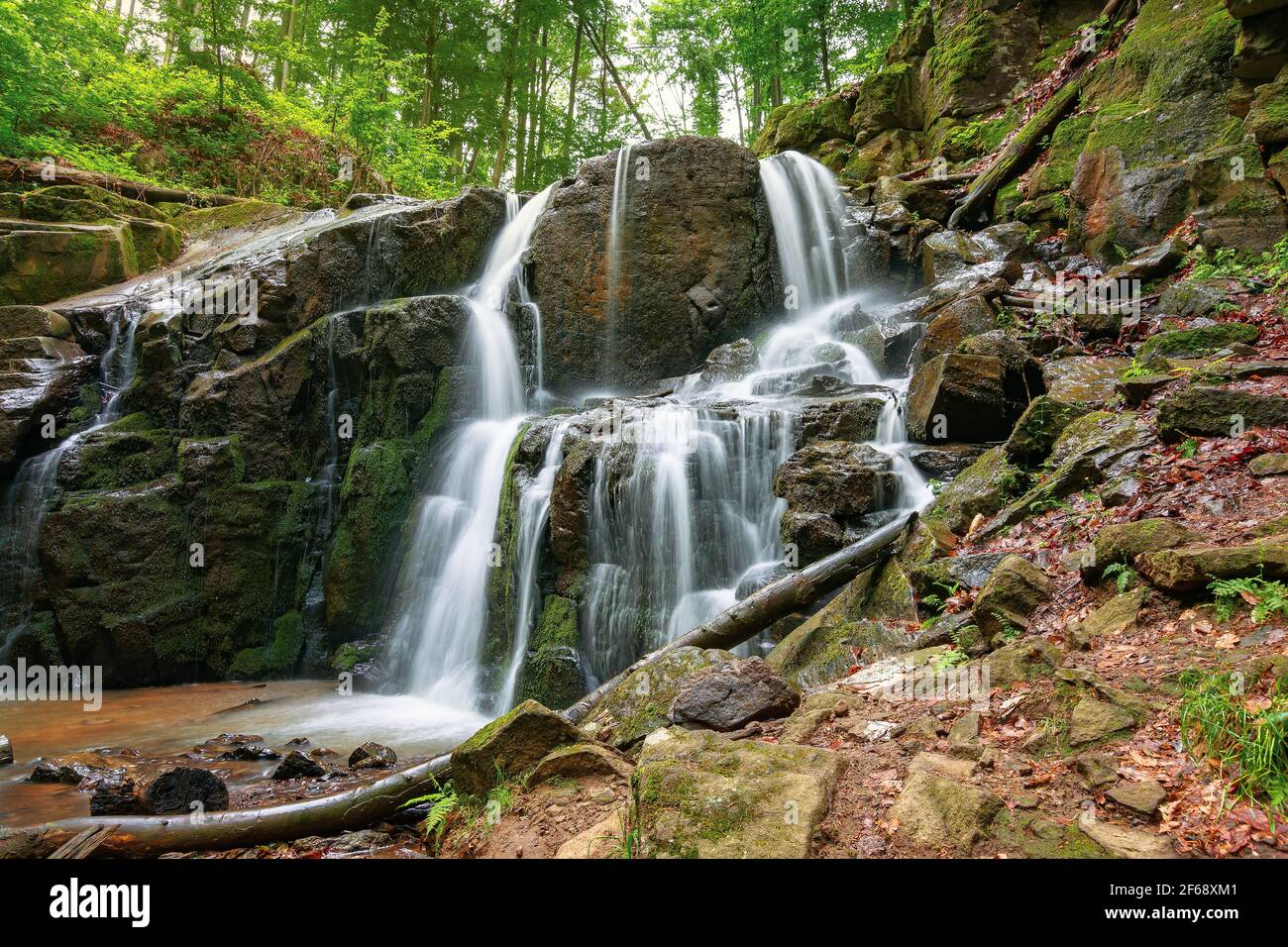 landscape with waterfall in spring. powerful water flow comes out of ...