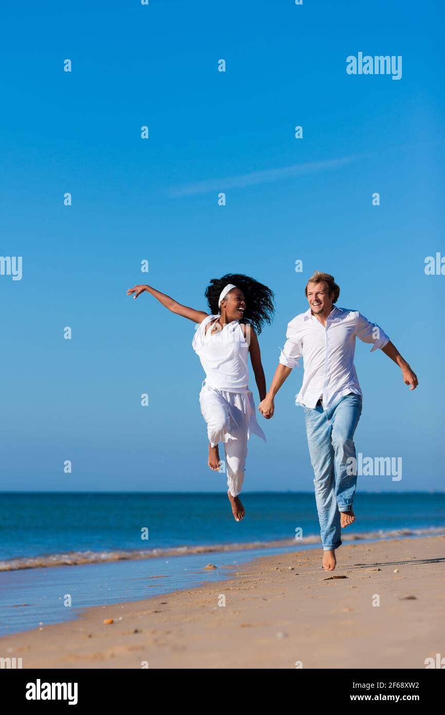 Couple - black woman and Caucasian man - walking and running down a ...