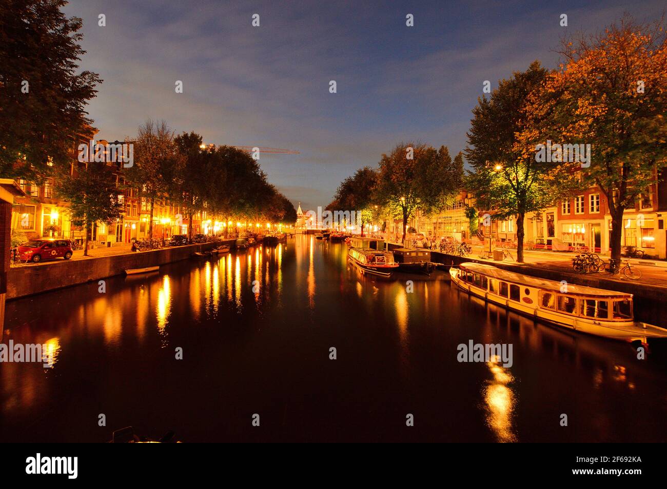 Channels in Amsterdam, the Netherlands illuminated at night with ...