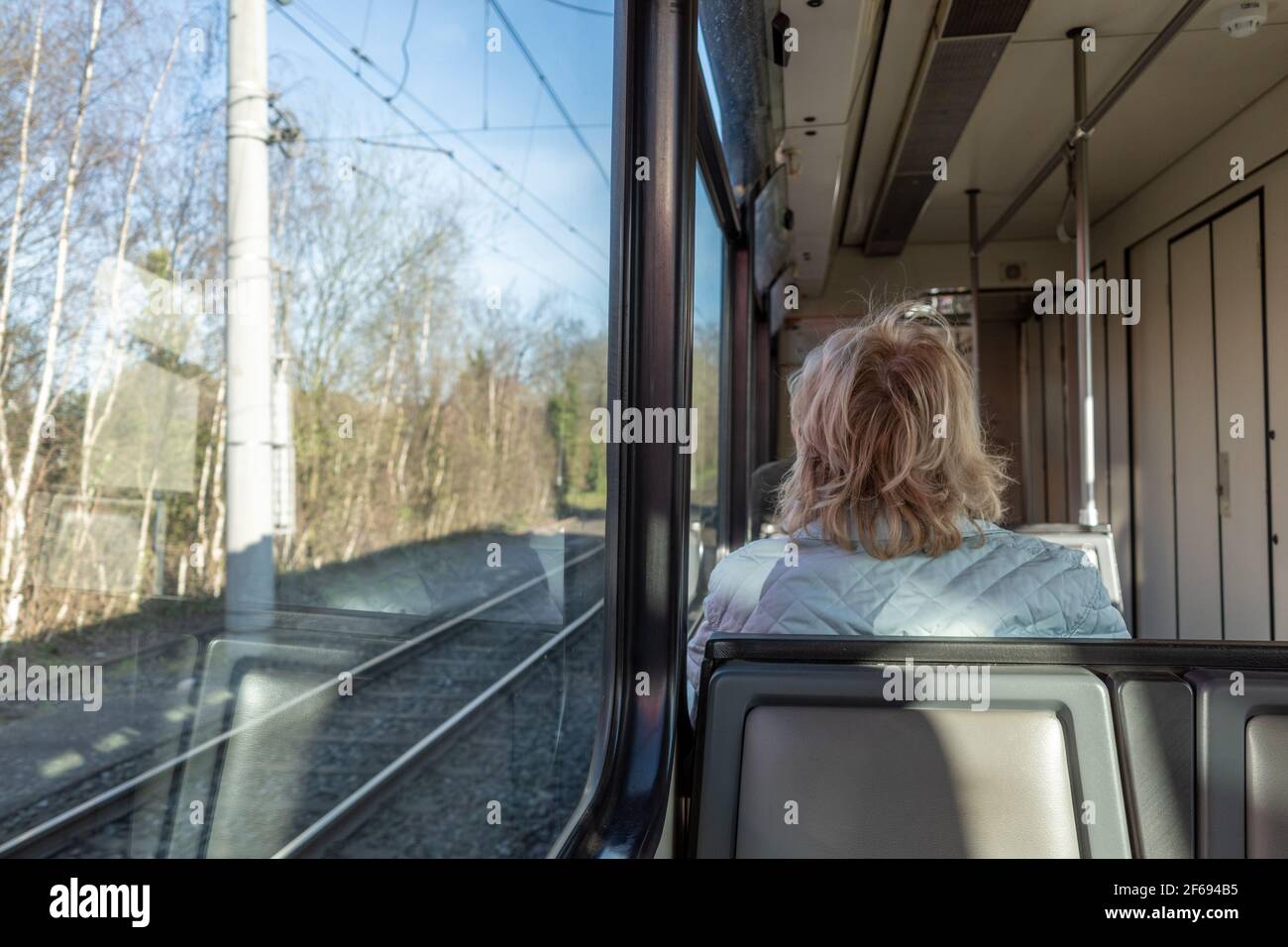 Selective focus view at the back of female passenger sit in light rail ...