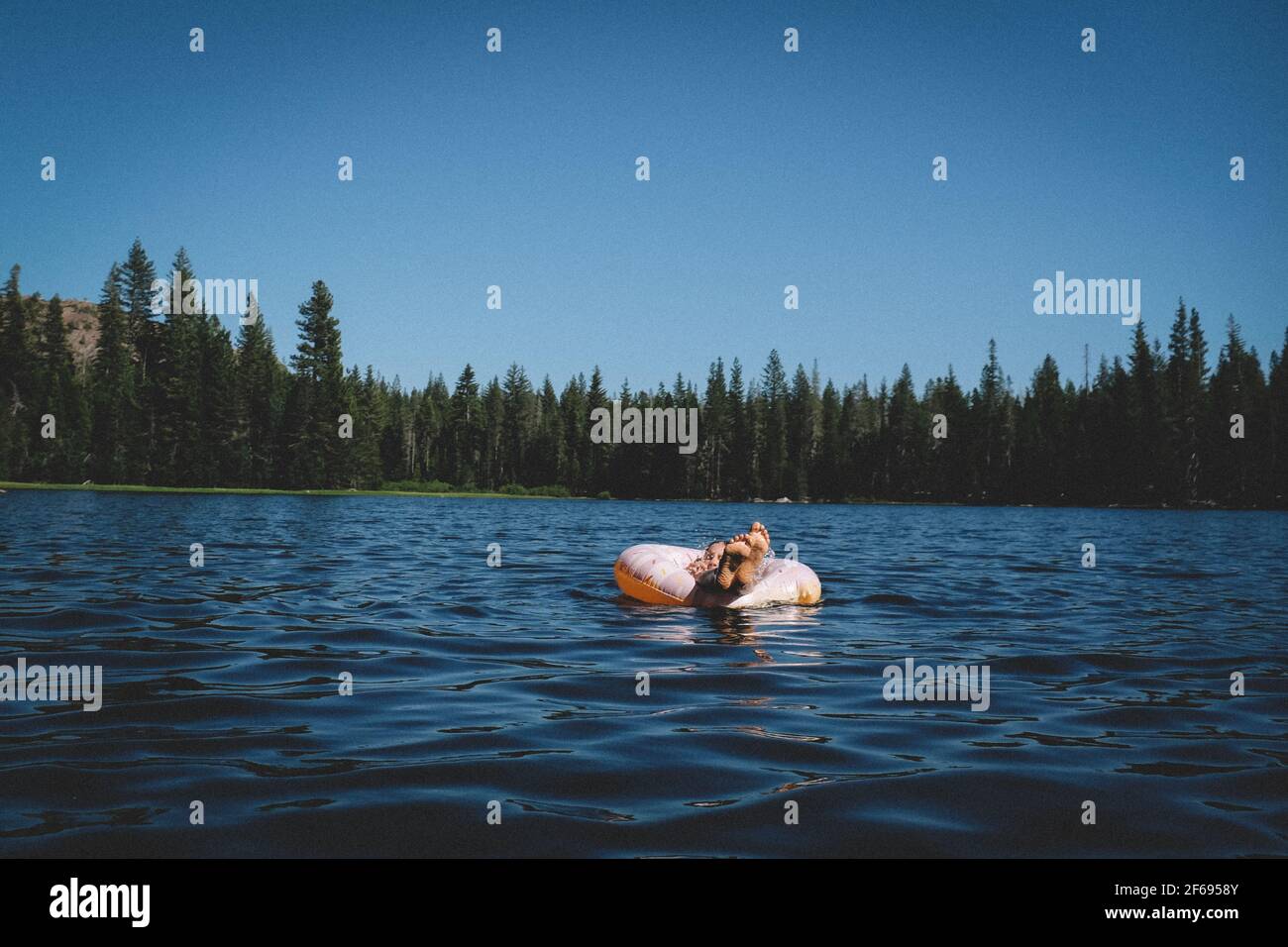 Small Feet Stick out of a Donut Floatie on a hot summer day Stock Photo ...