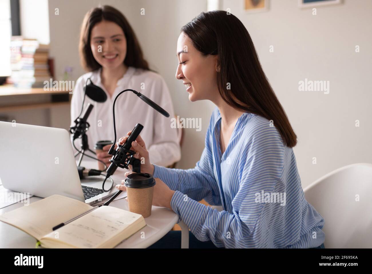 Cheerful Asian woman speaking during podcast with friend Stock Photo ...