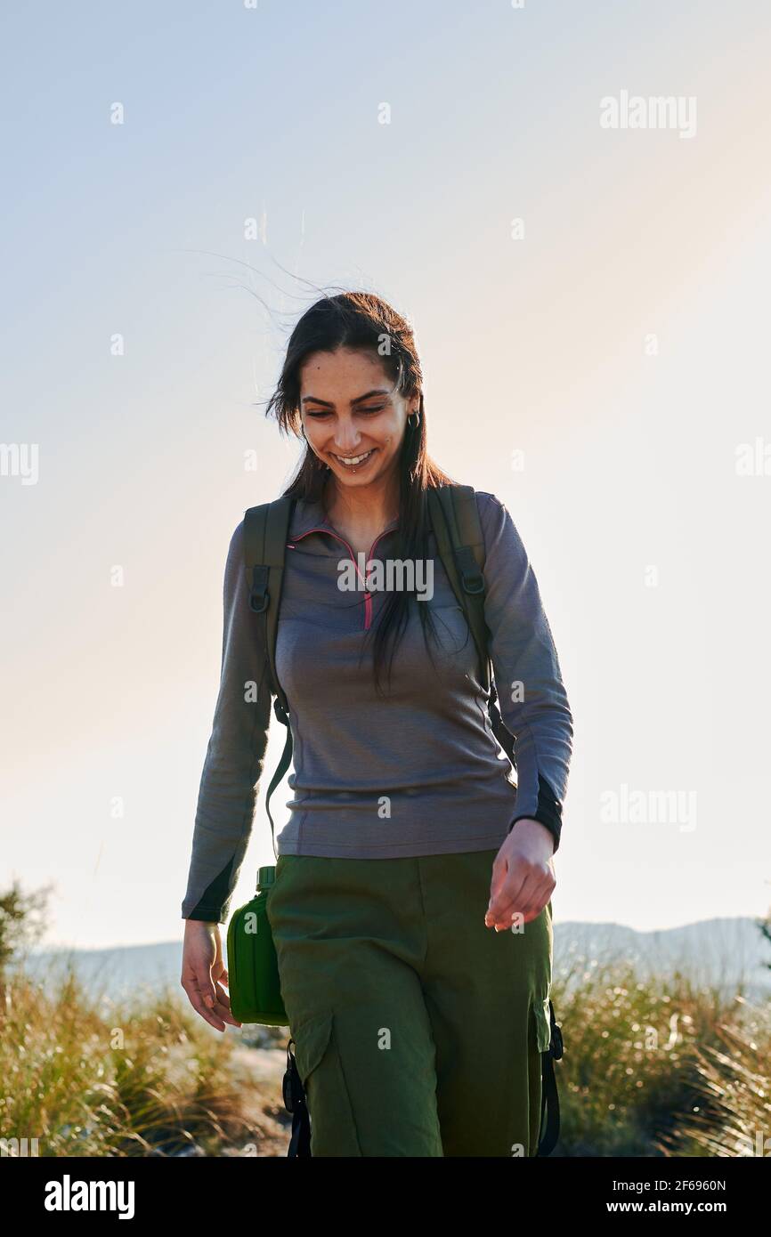 A female explorer walks along a dirt road observing nature Stock Photo ...
