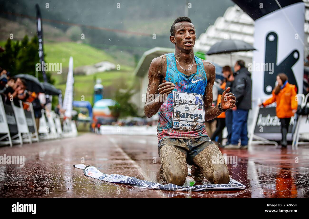 Selemon Barega winning, on the floor full of mud and giving thanks to ...