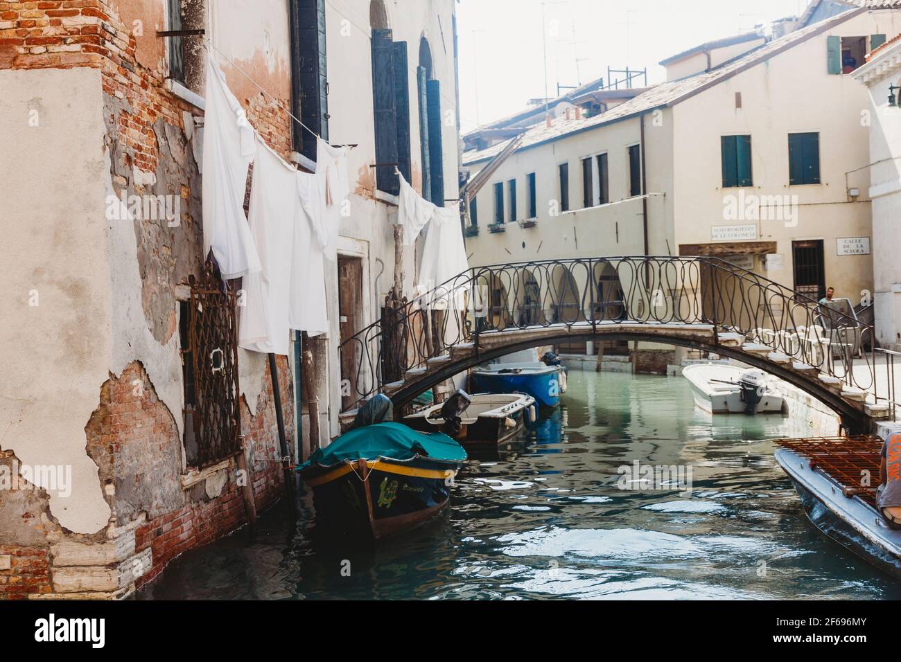 White sheets hanging outside shuttered windows above Venetian canal ...