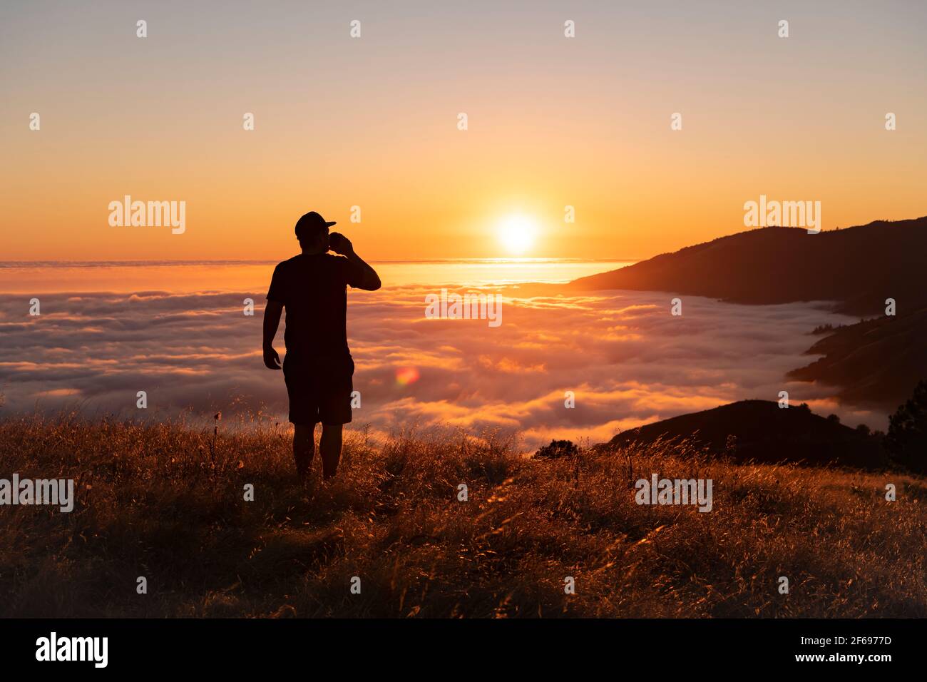 Hiking drinking a beer on top of mountain enjoying a sunset Stock Photo ...