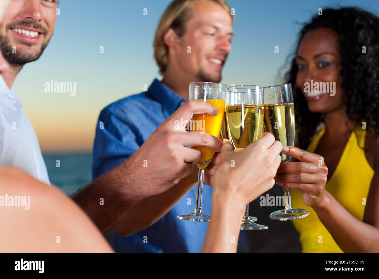 People (two couples) on the beach having a party, drinking and having a ...