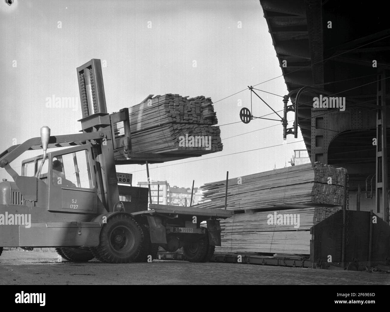 Bigger forklift in quay service, Liljeholmen. Loading timber on truck ...