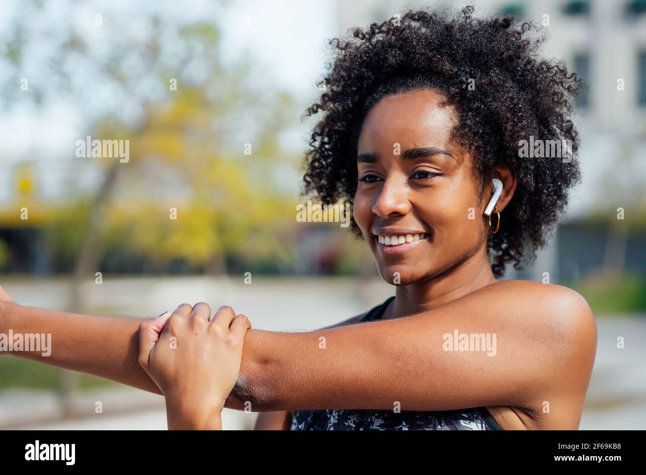 Afro athletic woman stretching arms before exercise Stock Photo - Alamy