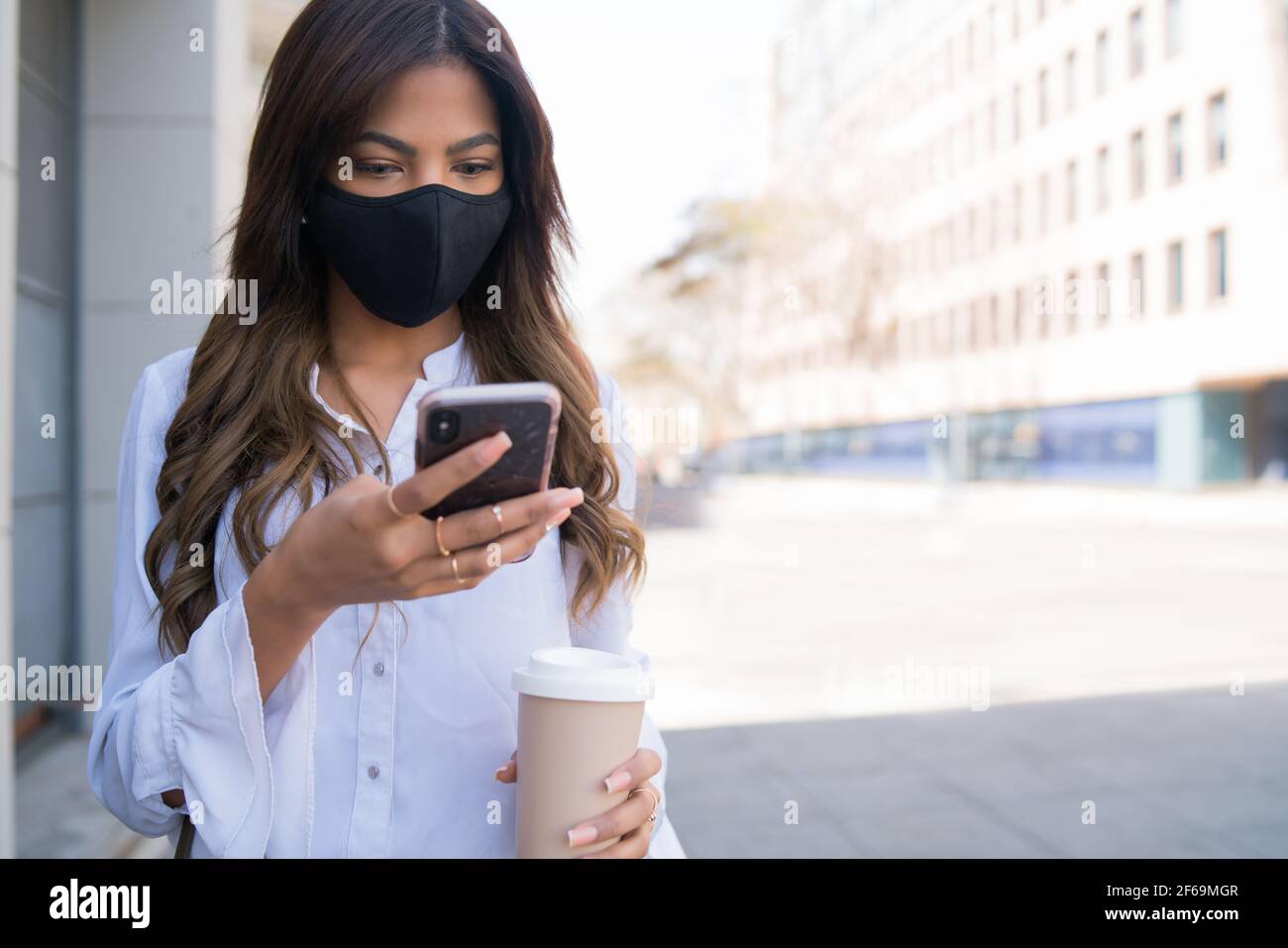 Young woman using her mobile phone outdoors Stock Photo - Alamy