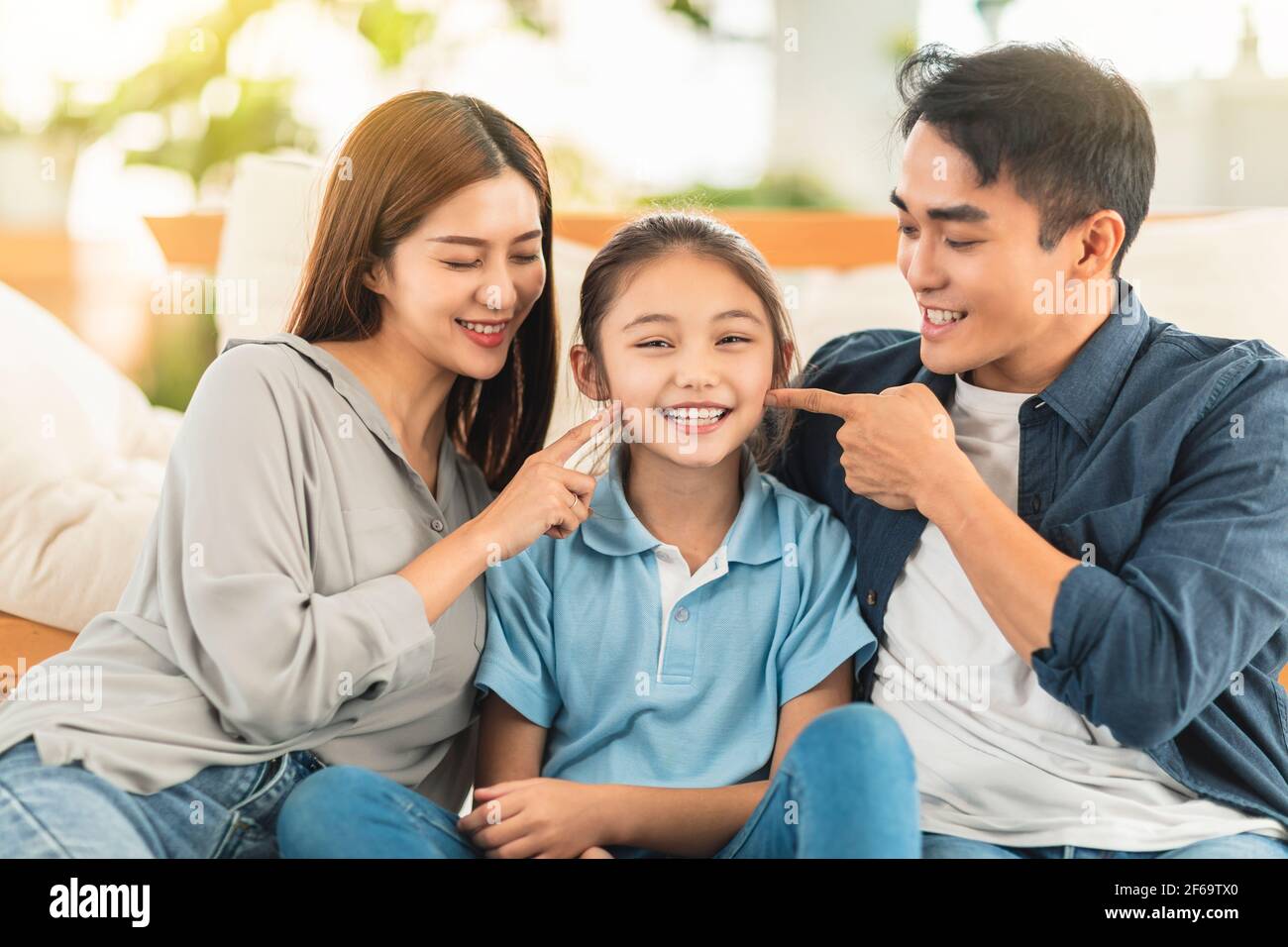Happy family smiling on the couch at home Stock Photo - Alamy