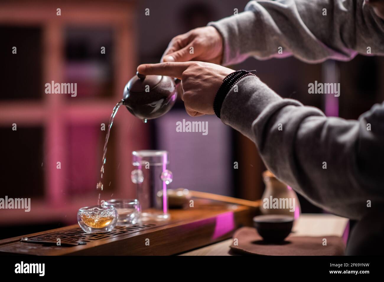 Close-up with the hands of a tea ceremony master in a tea shop, pouring ...