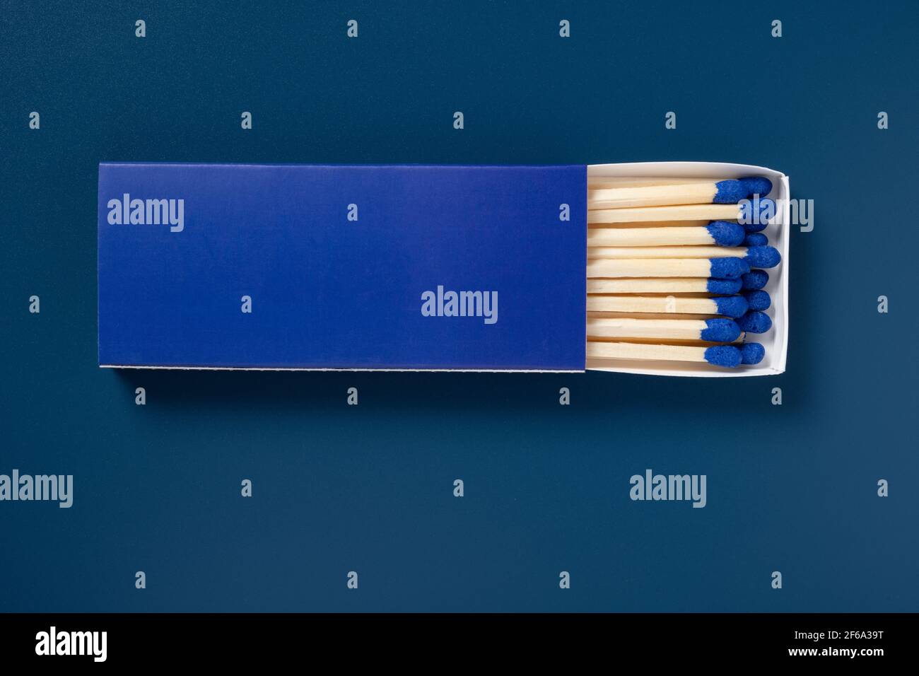 blue matchbox and blue match sticks on a black background Stock Photo ...