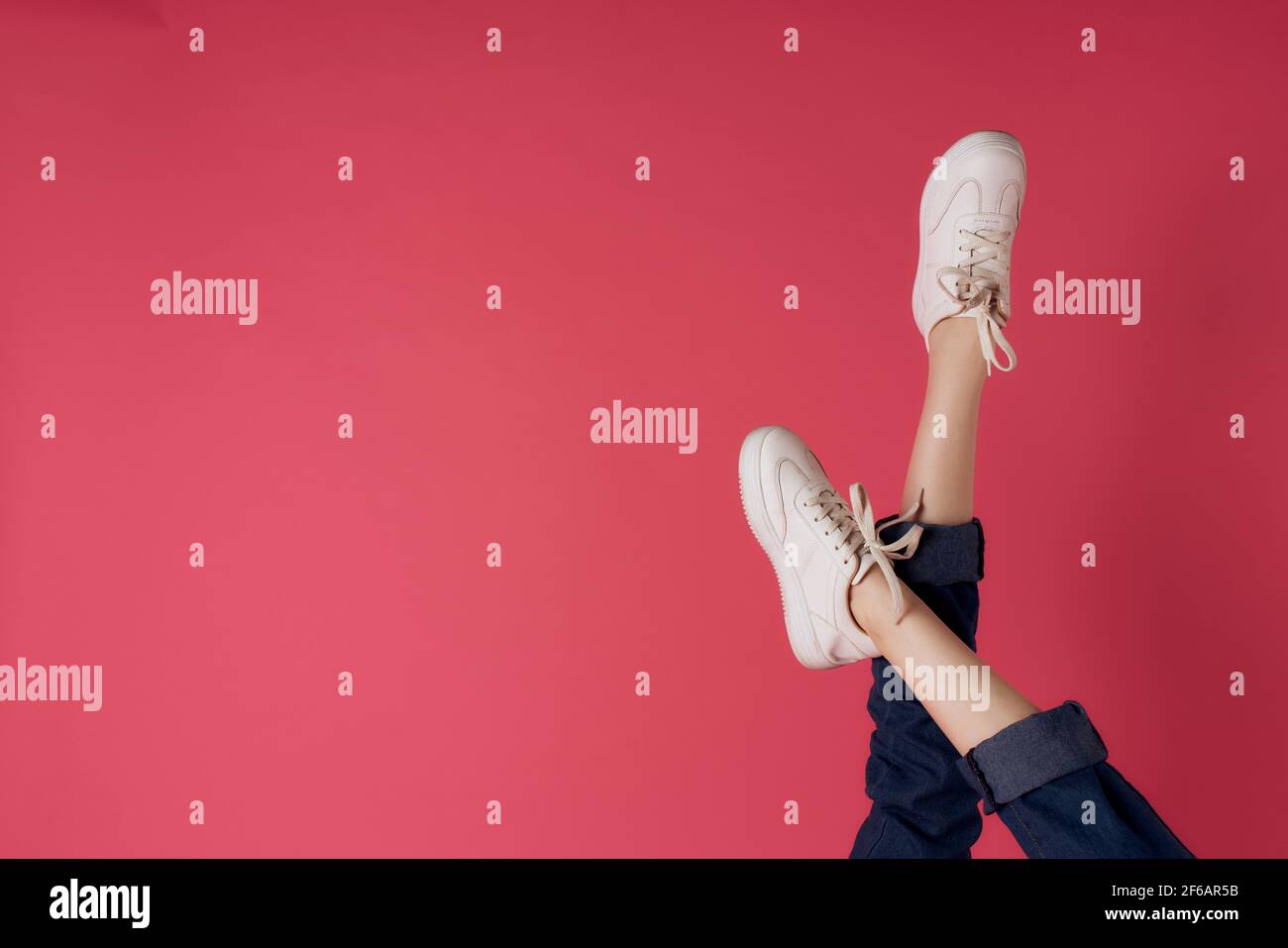White sneakers upside down legs movement street fashion pink background ...