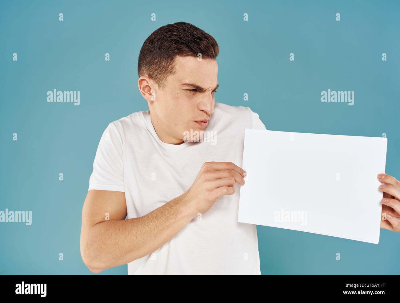 Guy with a white sheet of paper blue background advertising mocap ...