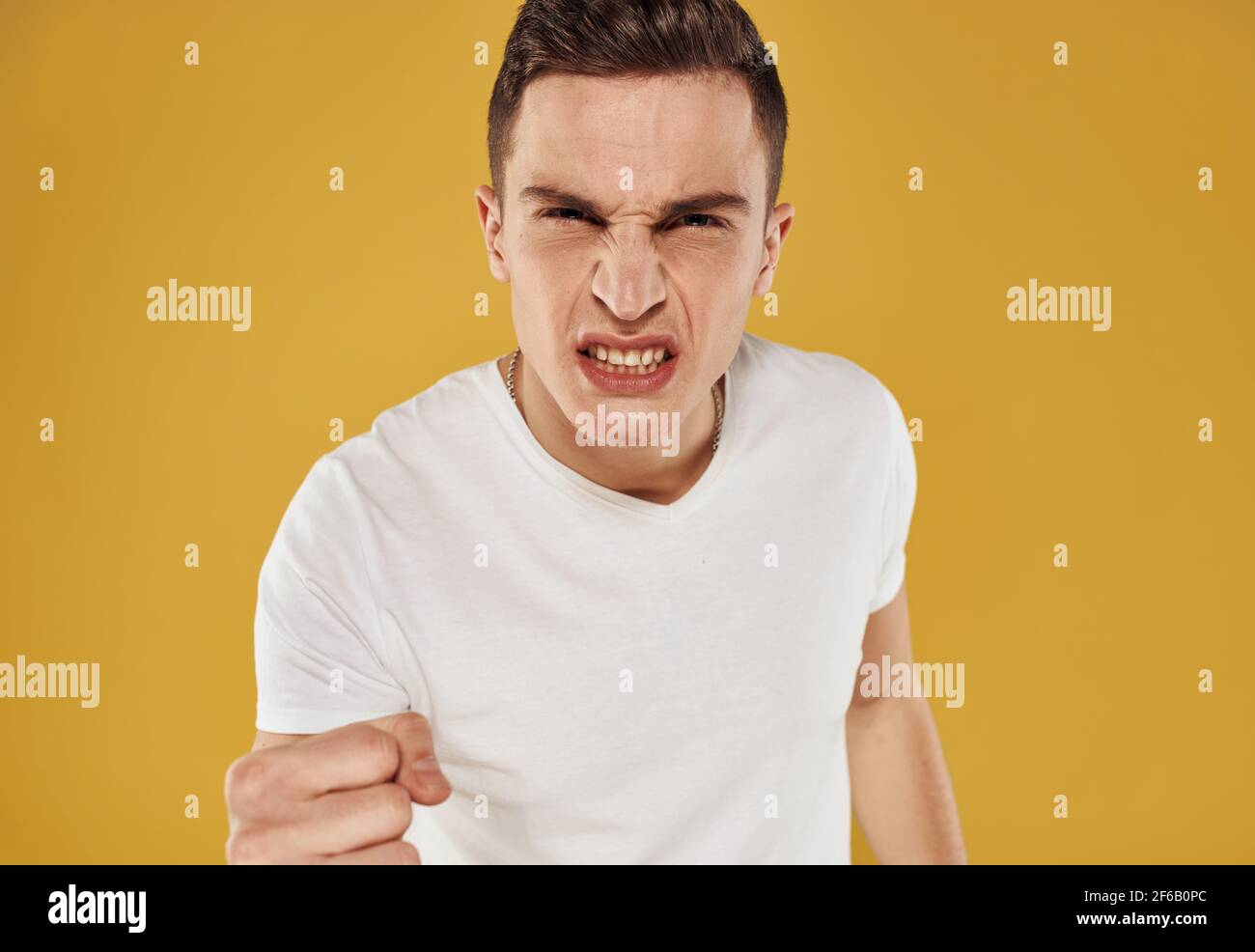 Angry man on a yellow background cry of emotion and stress Stock Photo ...