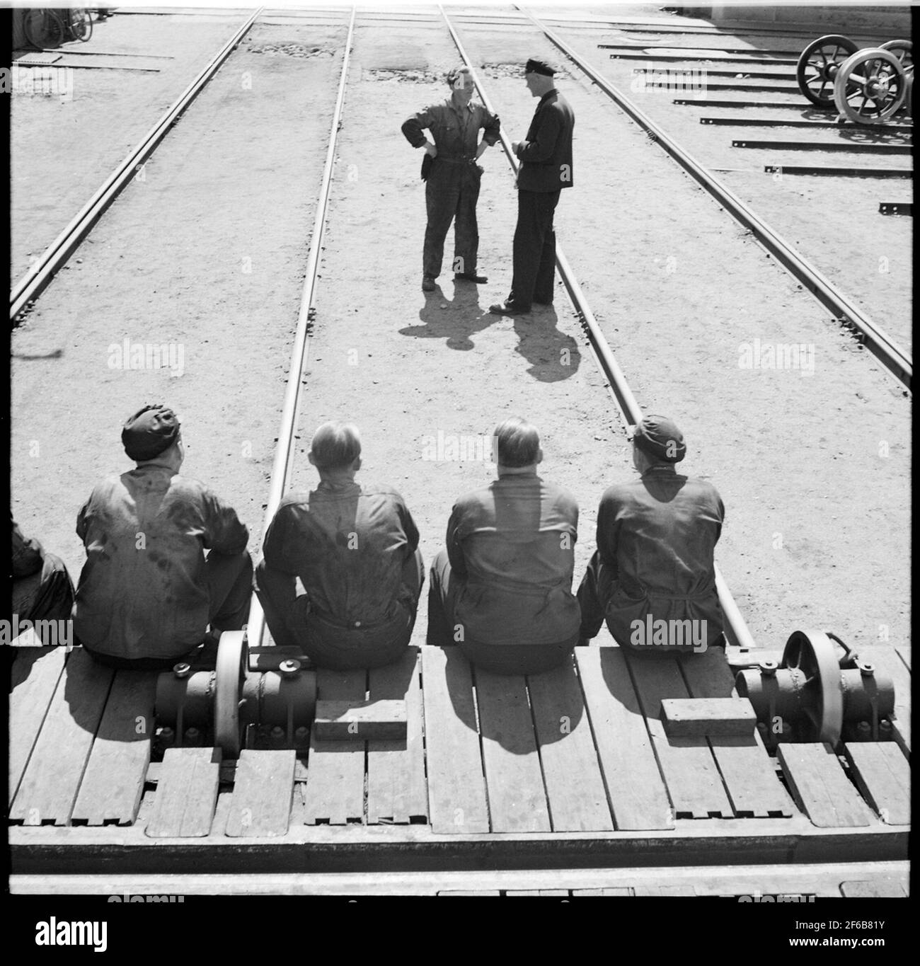 Workshop workers in conversation with railway staff Stock Photo - Alamy