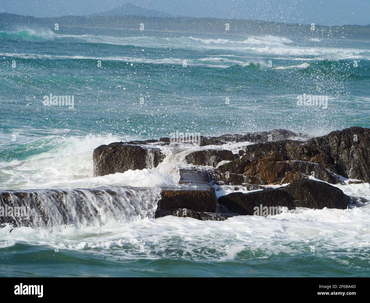 Sea spray splashing sparkling water drops into the sky, blue Ocean, as ...