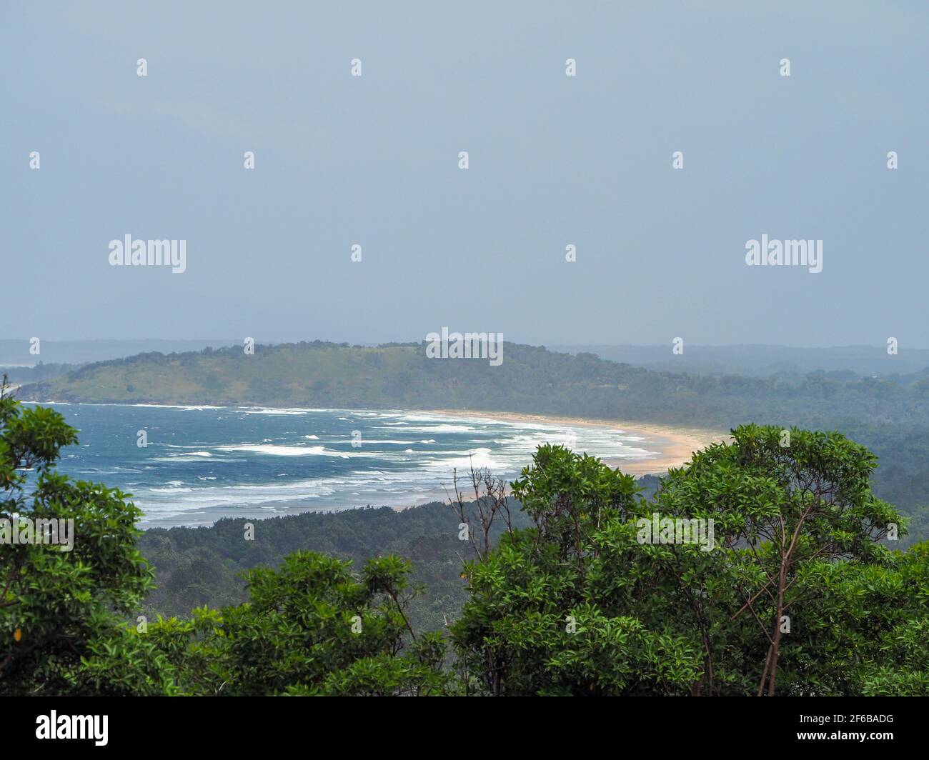 Scenic view of a beach trees and blue Pacific Ocean waves crashing into ...