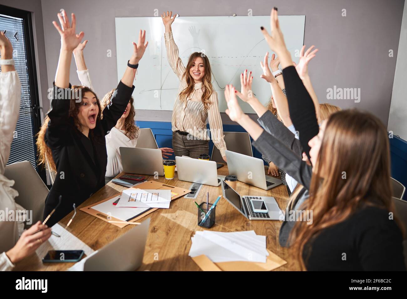 Cheerful creative team raising hands during meeting in office Stock ...