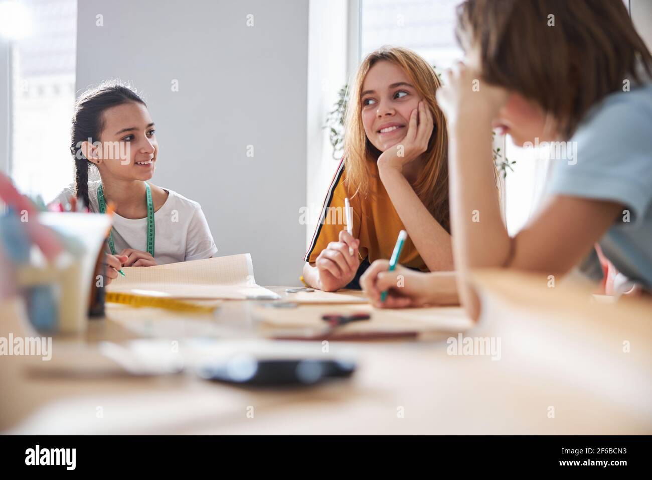 Joyful girls making sewing patterns in tailor workshop Stock Photo - Alamy