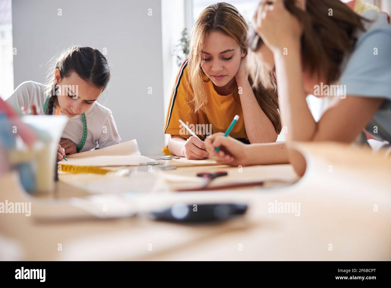 Adorable children making sewing patterns in tailor atelier Stock Photo ...