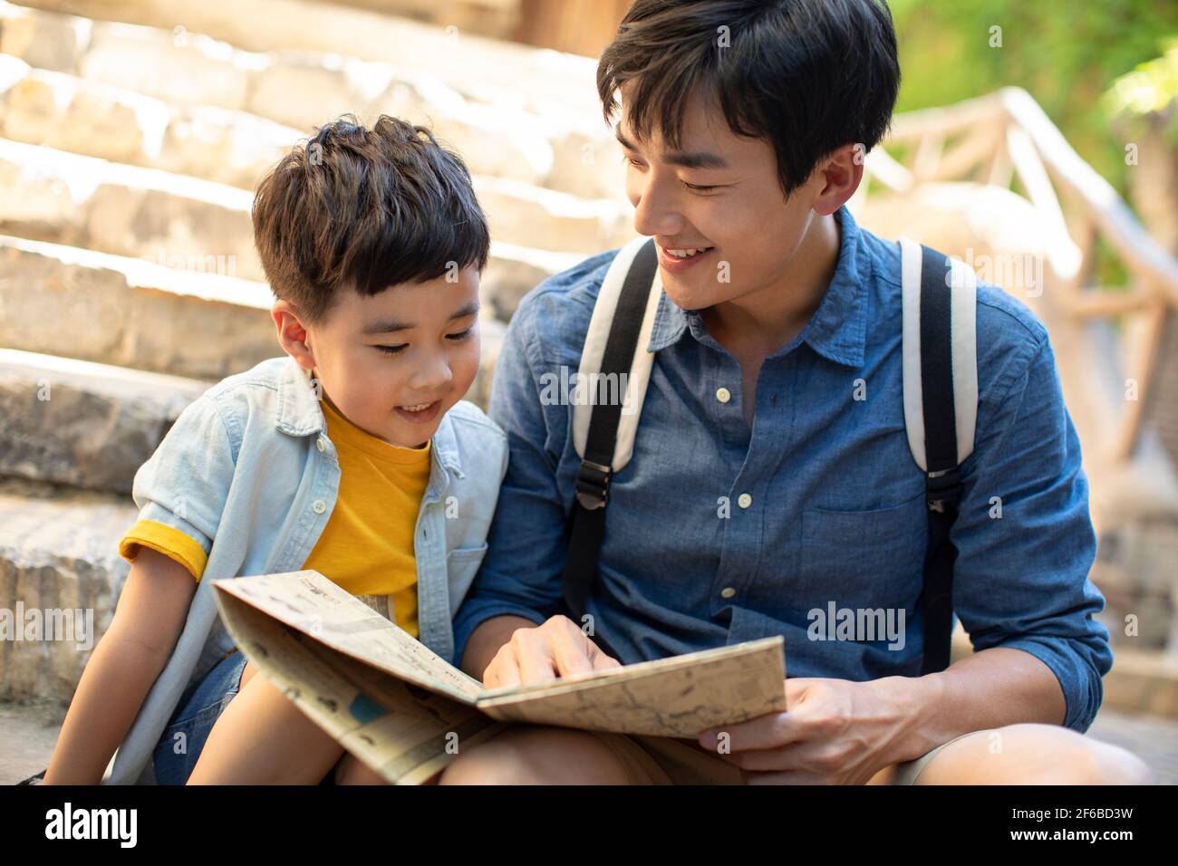 Chinese father and son looking at map outdoors Stock Photo - Alamy