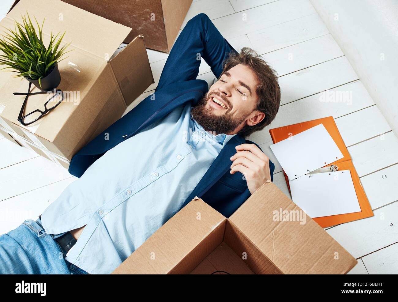 man lying on the floor with documents office box with things ...