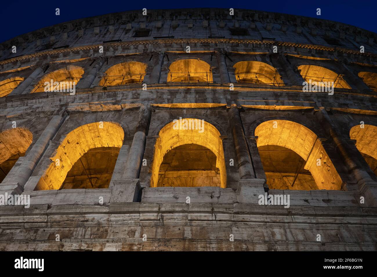 Arches of the Colosseum amphitheatre illuminated at night in Rome ...