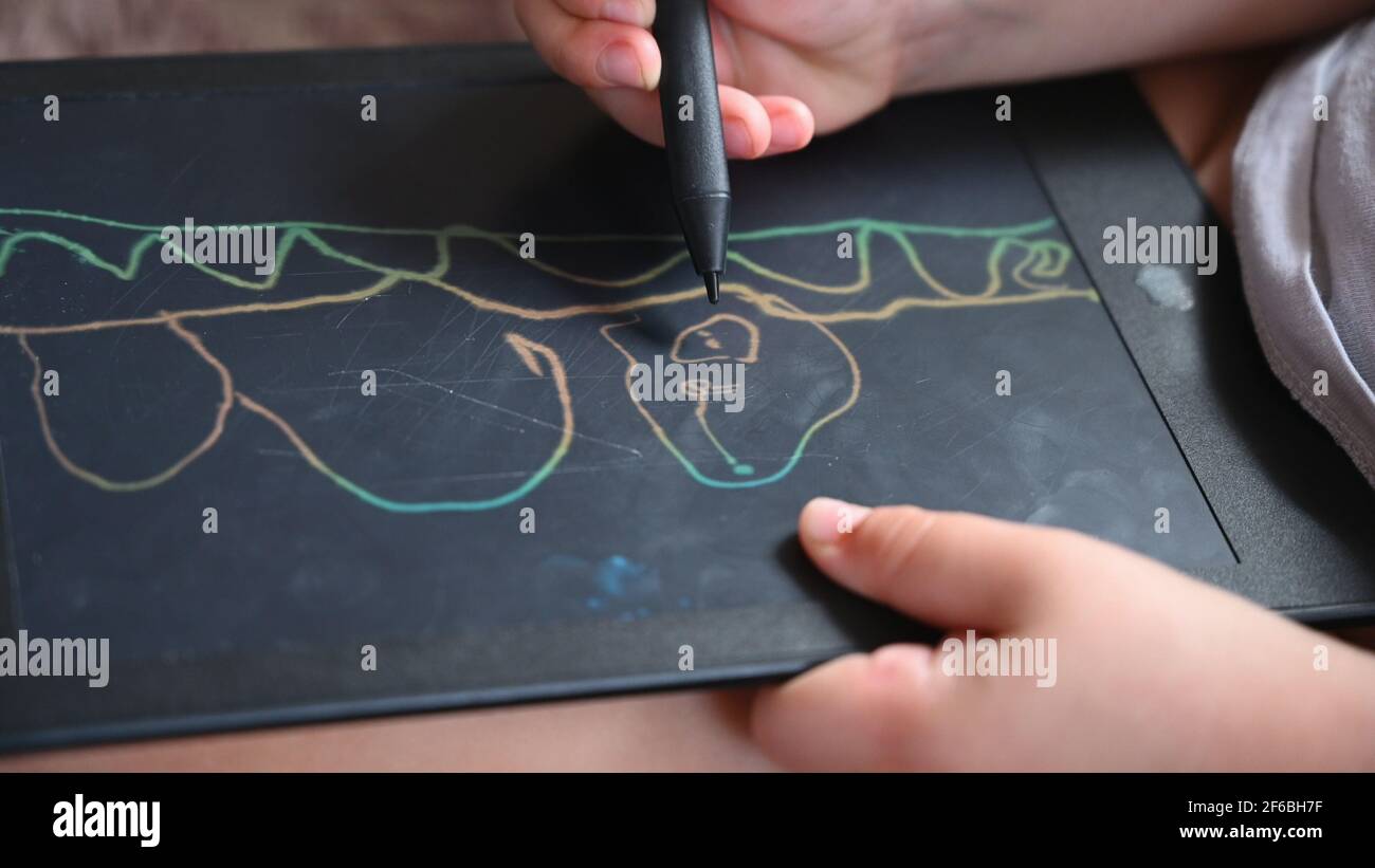 Little child learns to draw on a tablet Stock Photo - Alamy