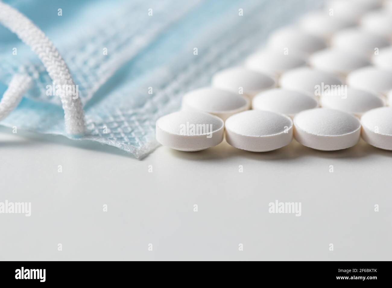 Rows of pills and medical masks on a white background. Health care ...