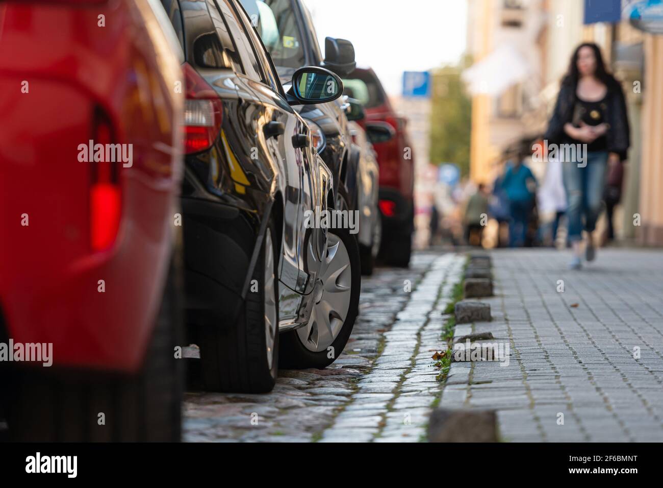 rows of different cars parked along the roadside in crowded city Stock ...