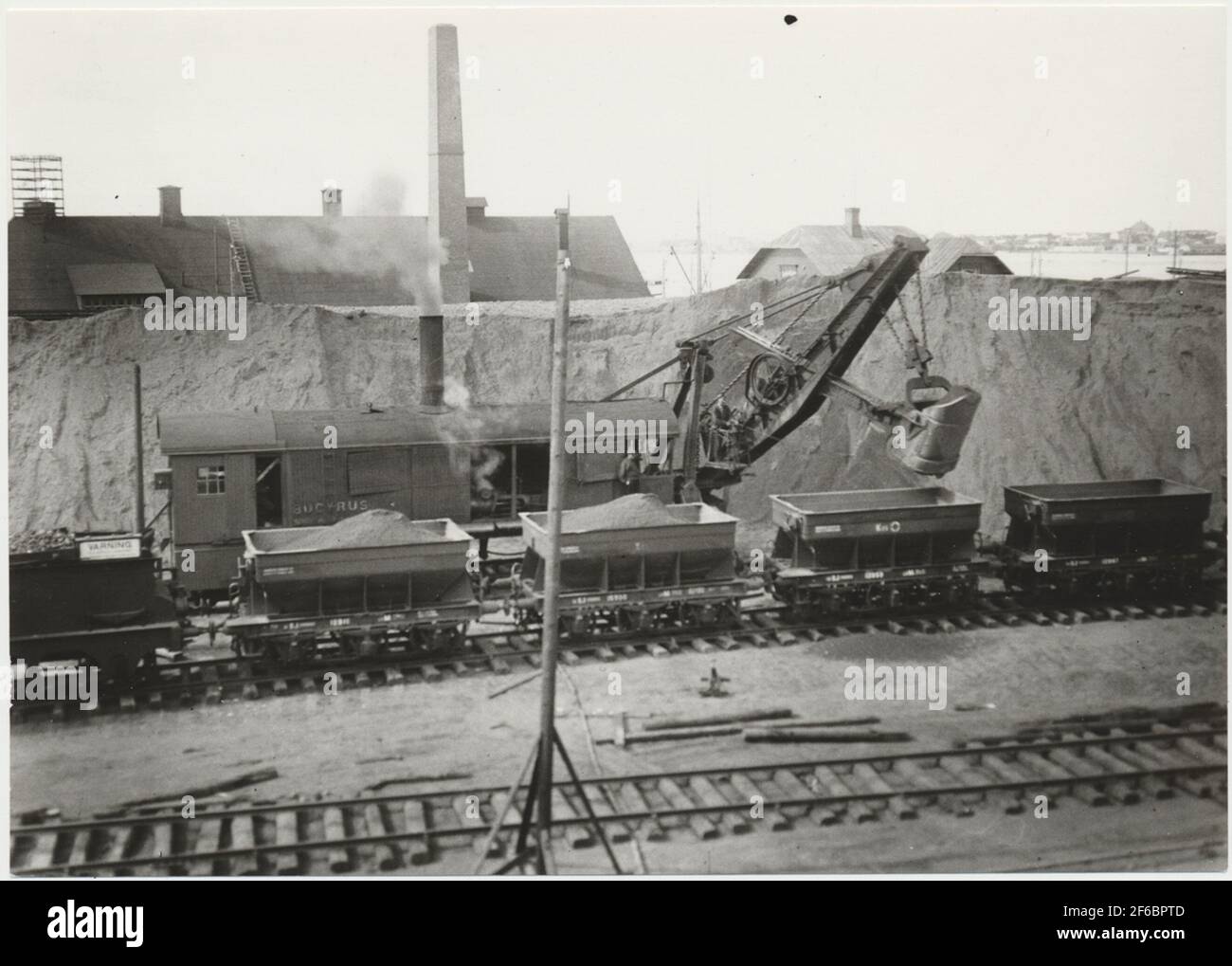 Steam meal loading crane loading ore carts on black island in Luleå ...