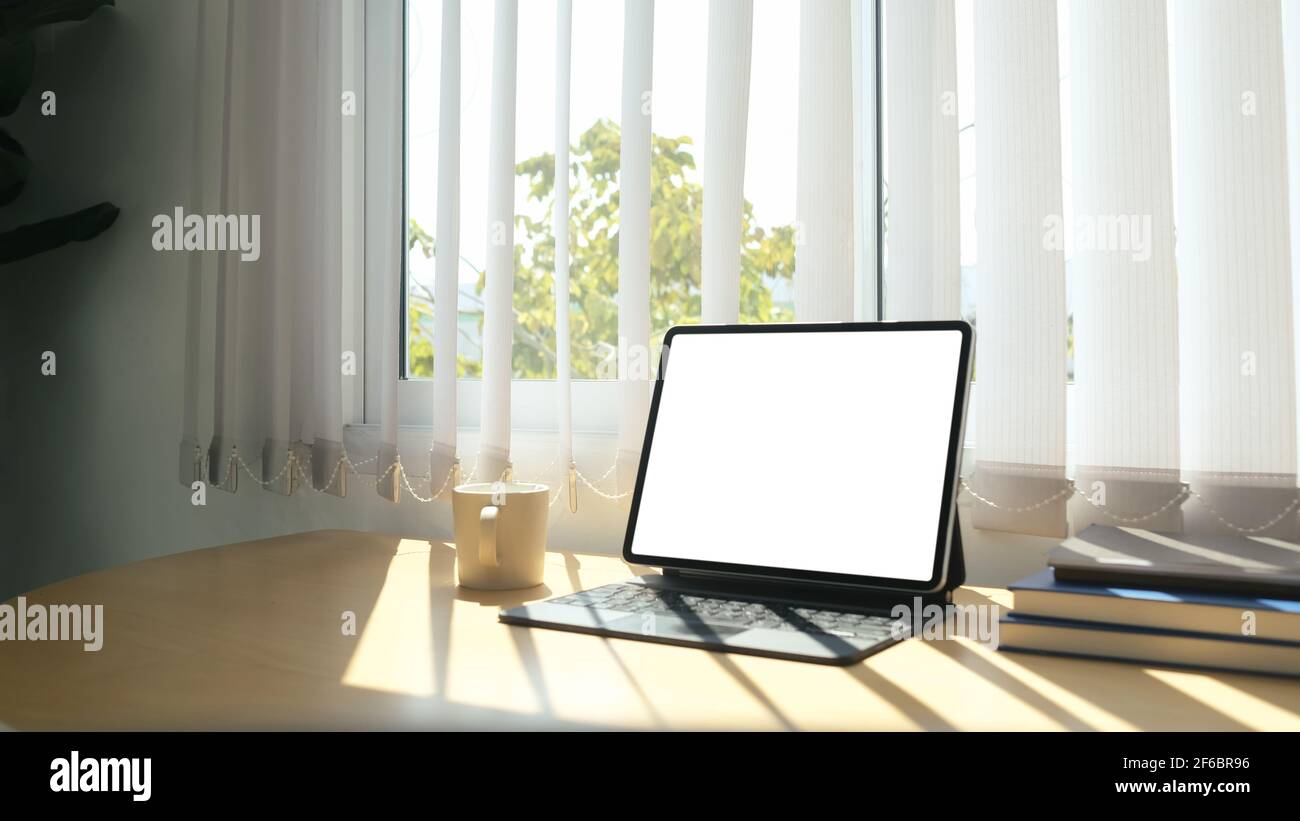 Close up view of computer tablet, coffee cup and books beside the ...