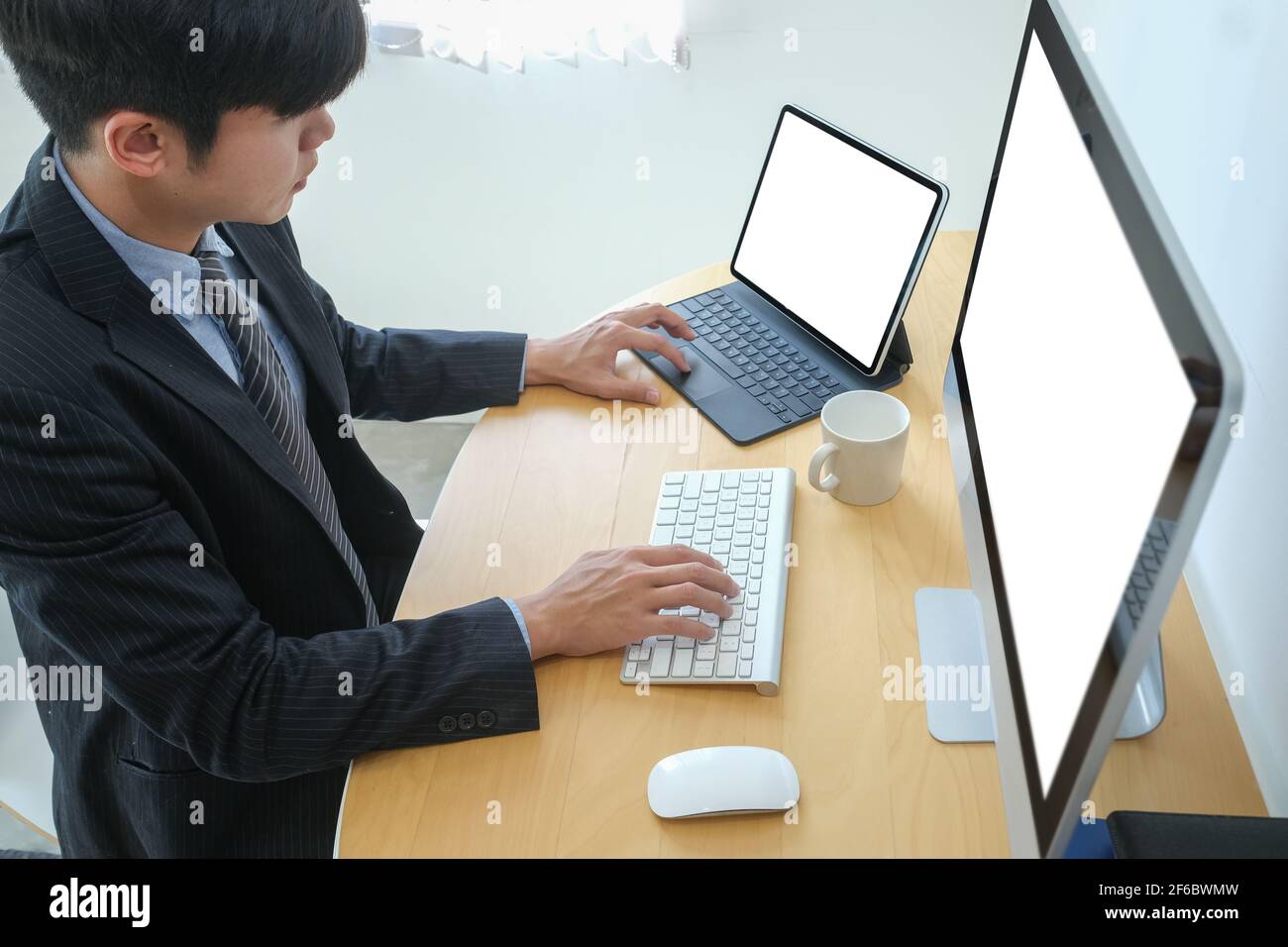 Young man accountant working with computer and digital tablet at his ...