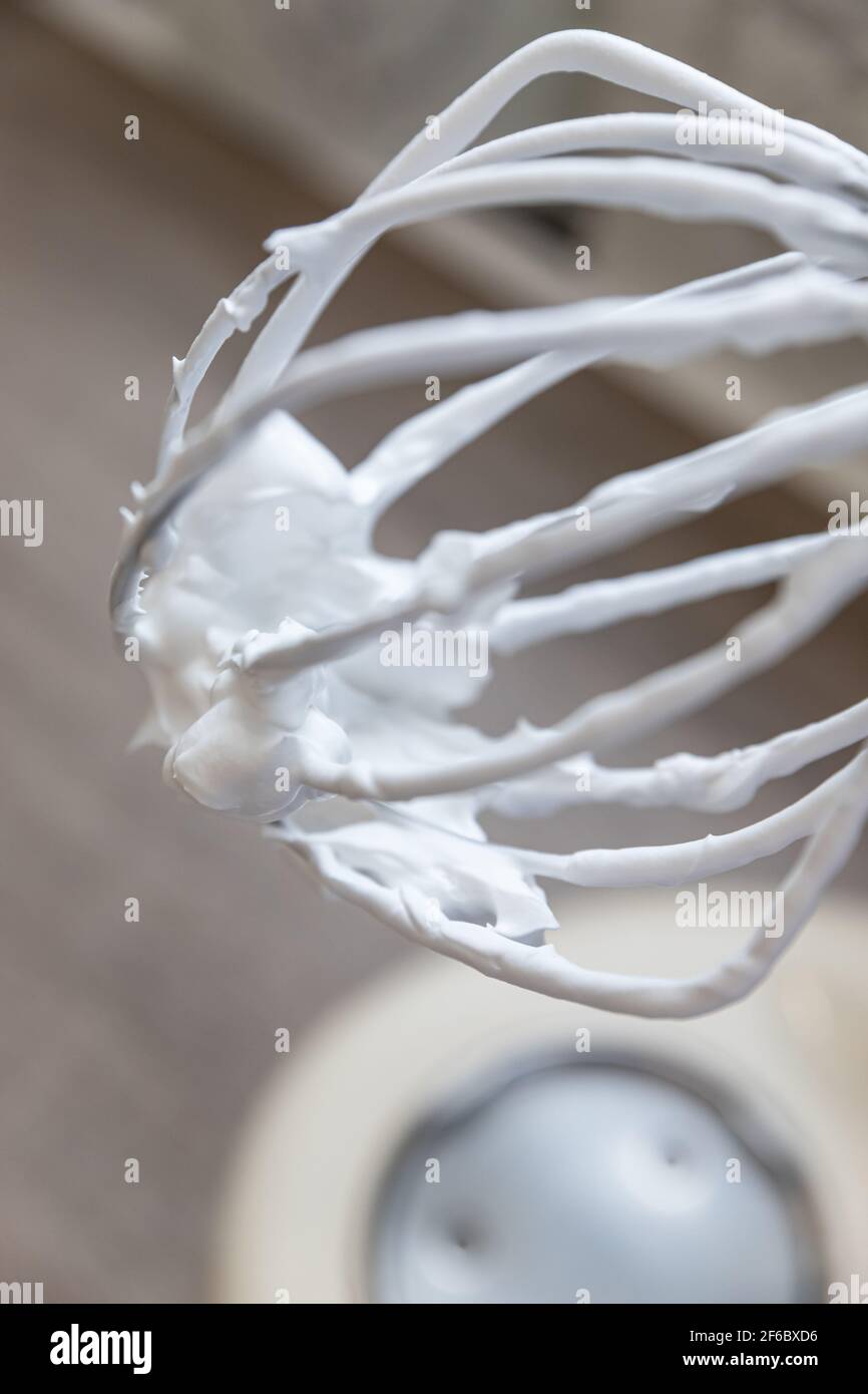 Metal whisk with whipping egg whites with sugar in a planetary mixer ...