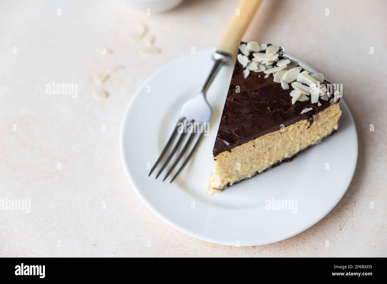 Slice of no baked creamy cheesecake with chocolate glaze and almond ...