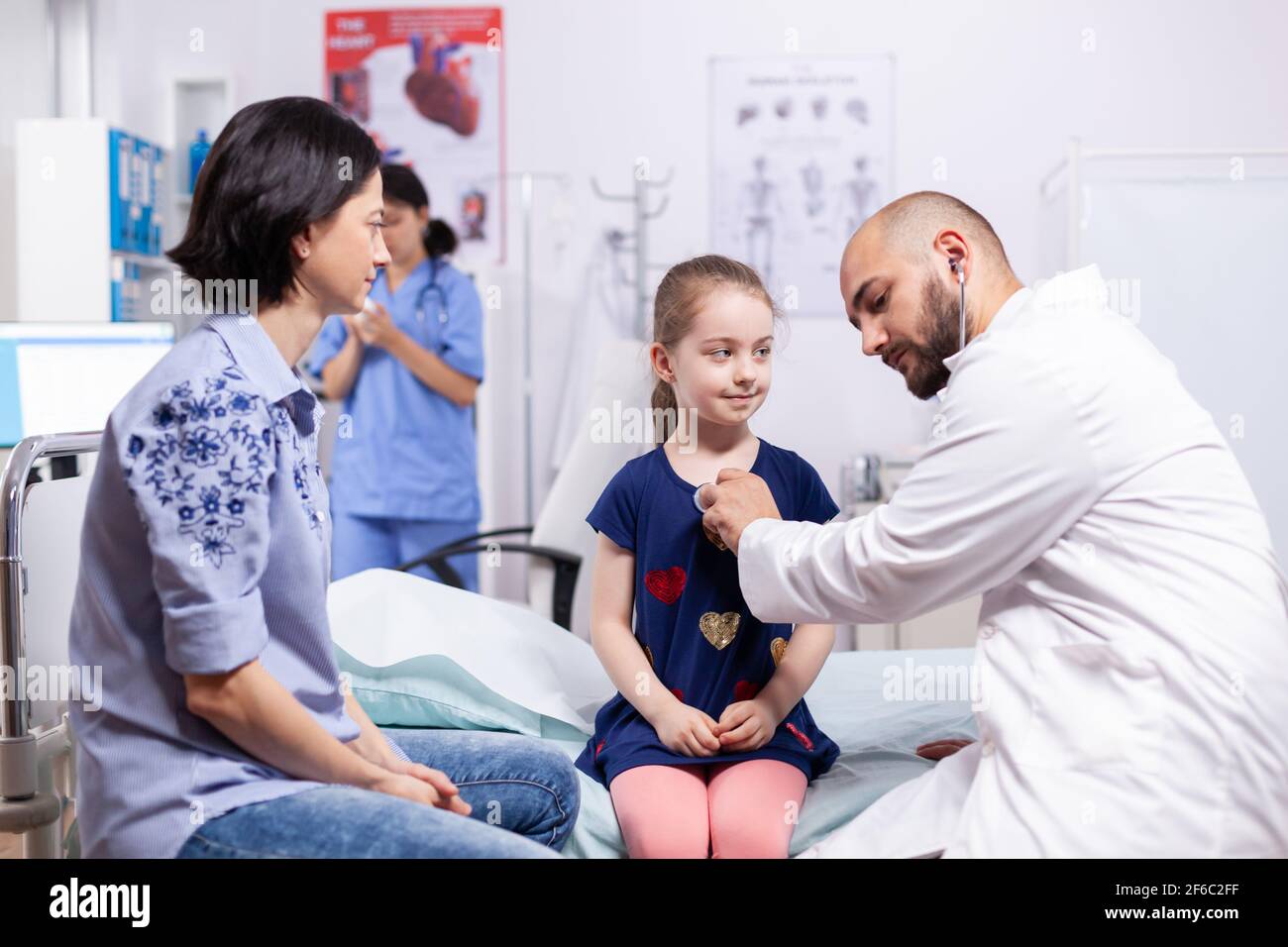 Doctor pediatry giving child checkup in medical office using ...
