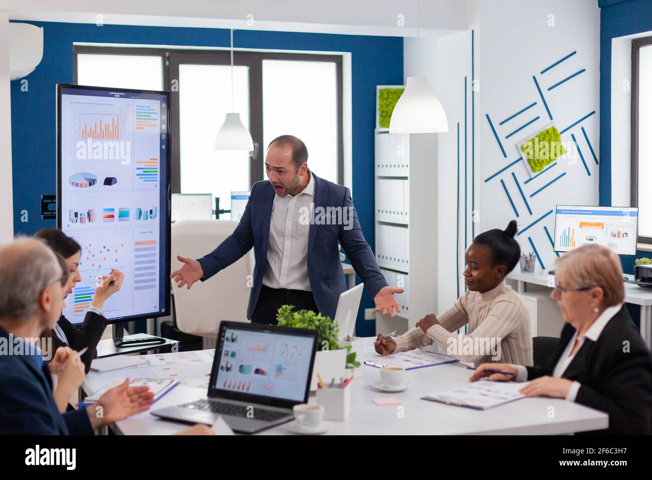 Business executive owner criticizing multiethnic workers for corporate ...