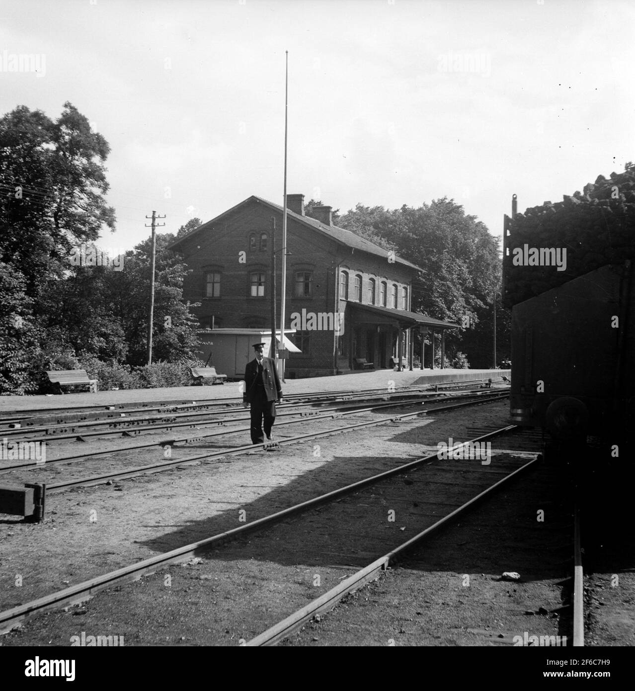 A railway officer goes over the tracks. Simrishamn station was built in ...