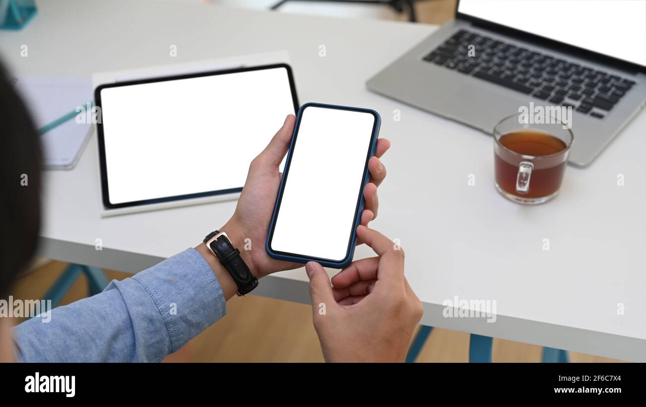 Close up view of businessman using multiple devices at workplace and ...