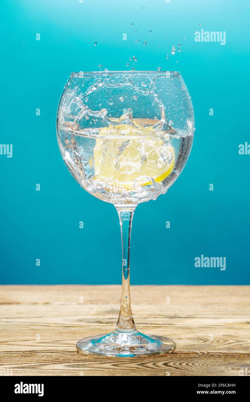 Clean fresh clear water with lemon and splashes on a blue background ...