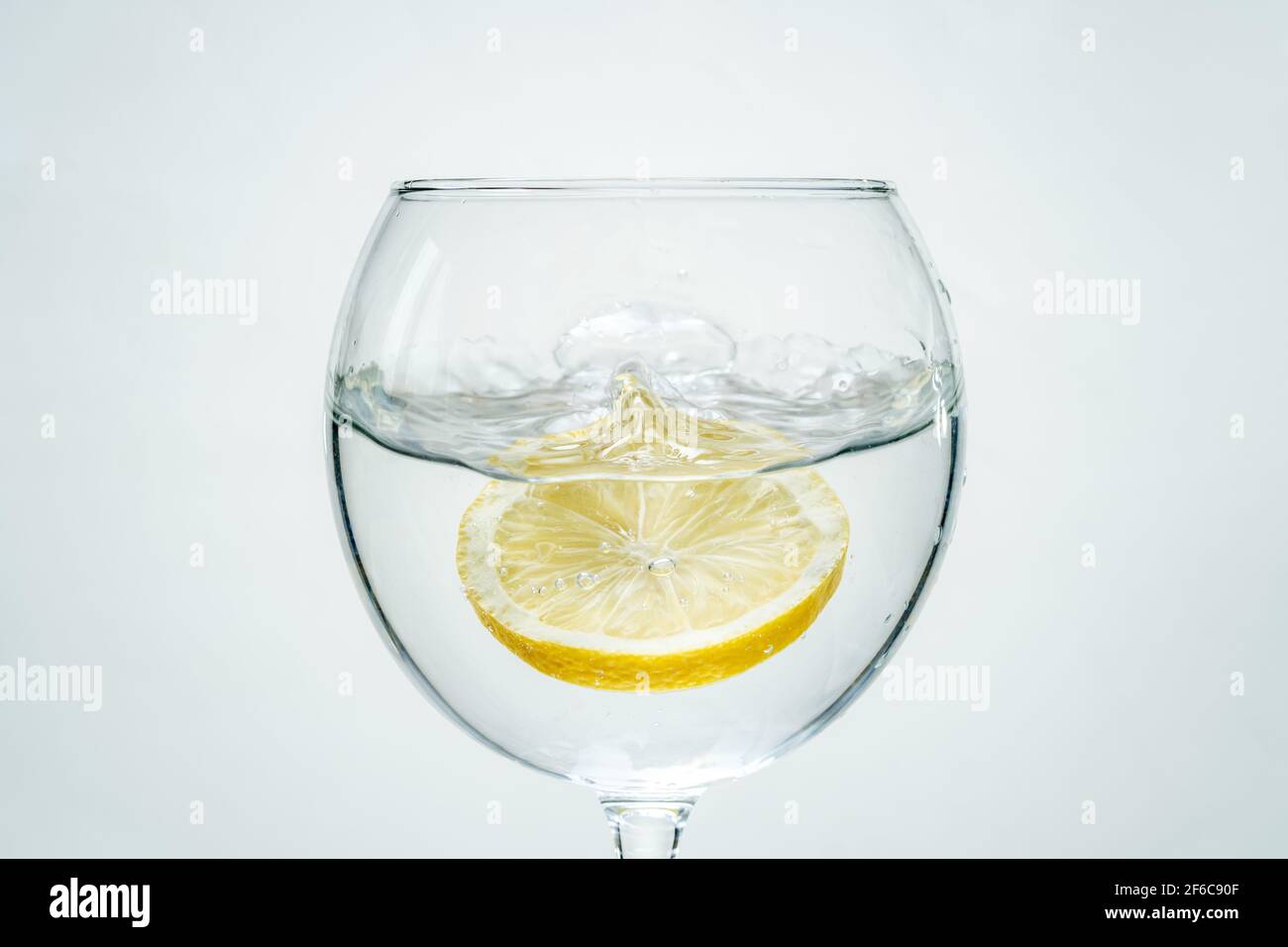 Clean fresh clear water with lemon and splashes on a white background ...