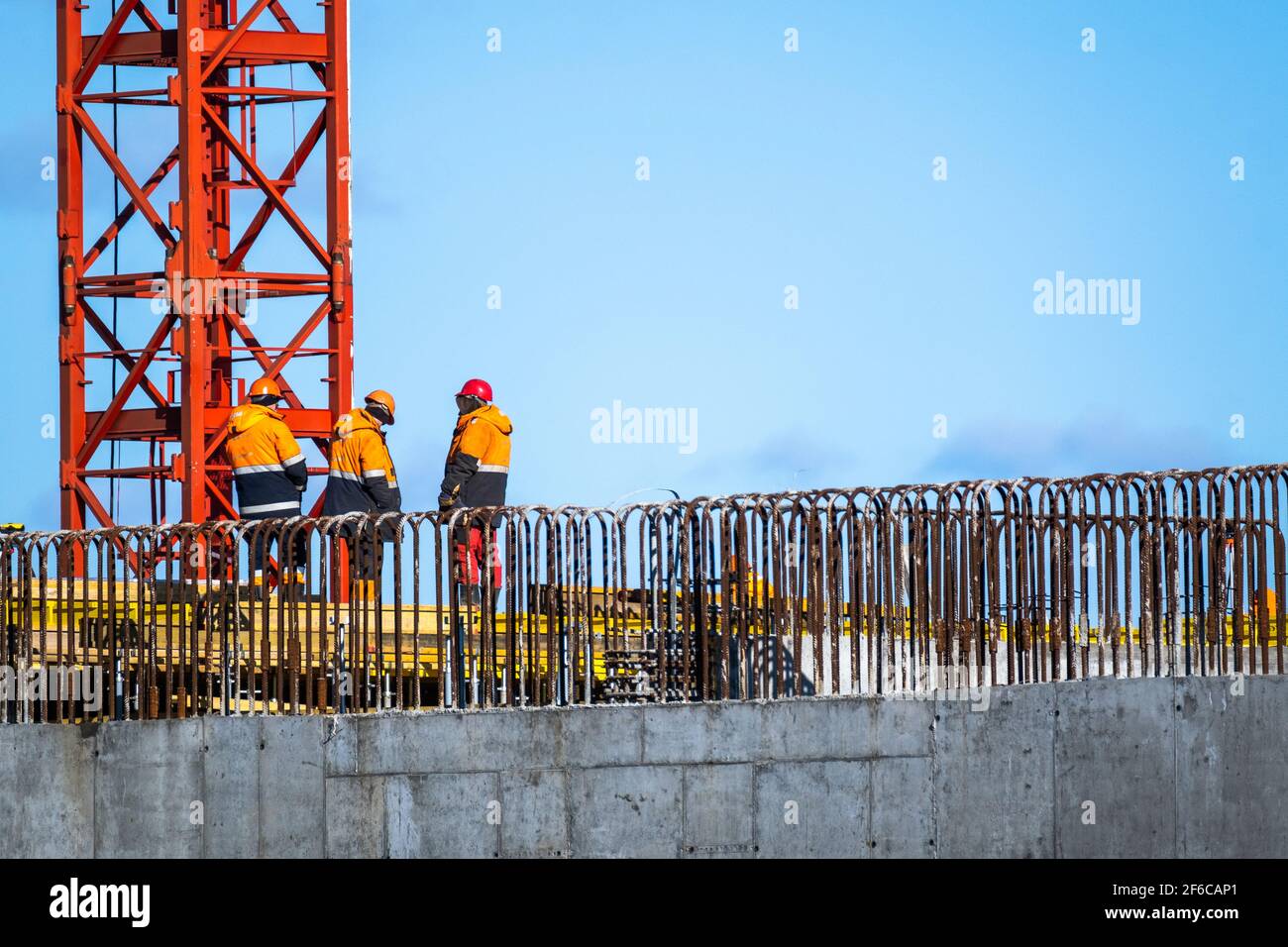 Builders walking on bridge near unfinished building Stock Photo - Alamy