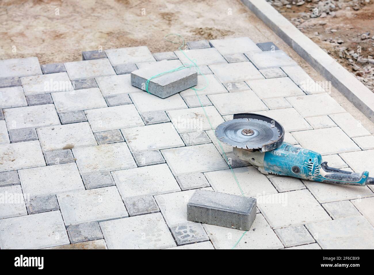 A worn-out electric angle grinder with a diamond cut-off disc on it at ...